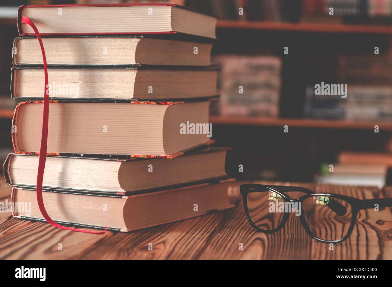 Old books stand against the background of bookshelves. Library Stock ...