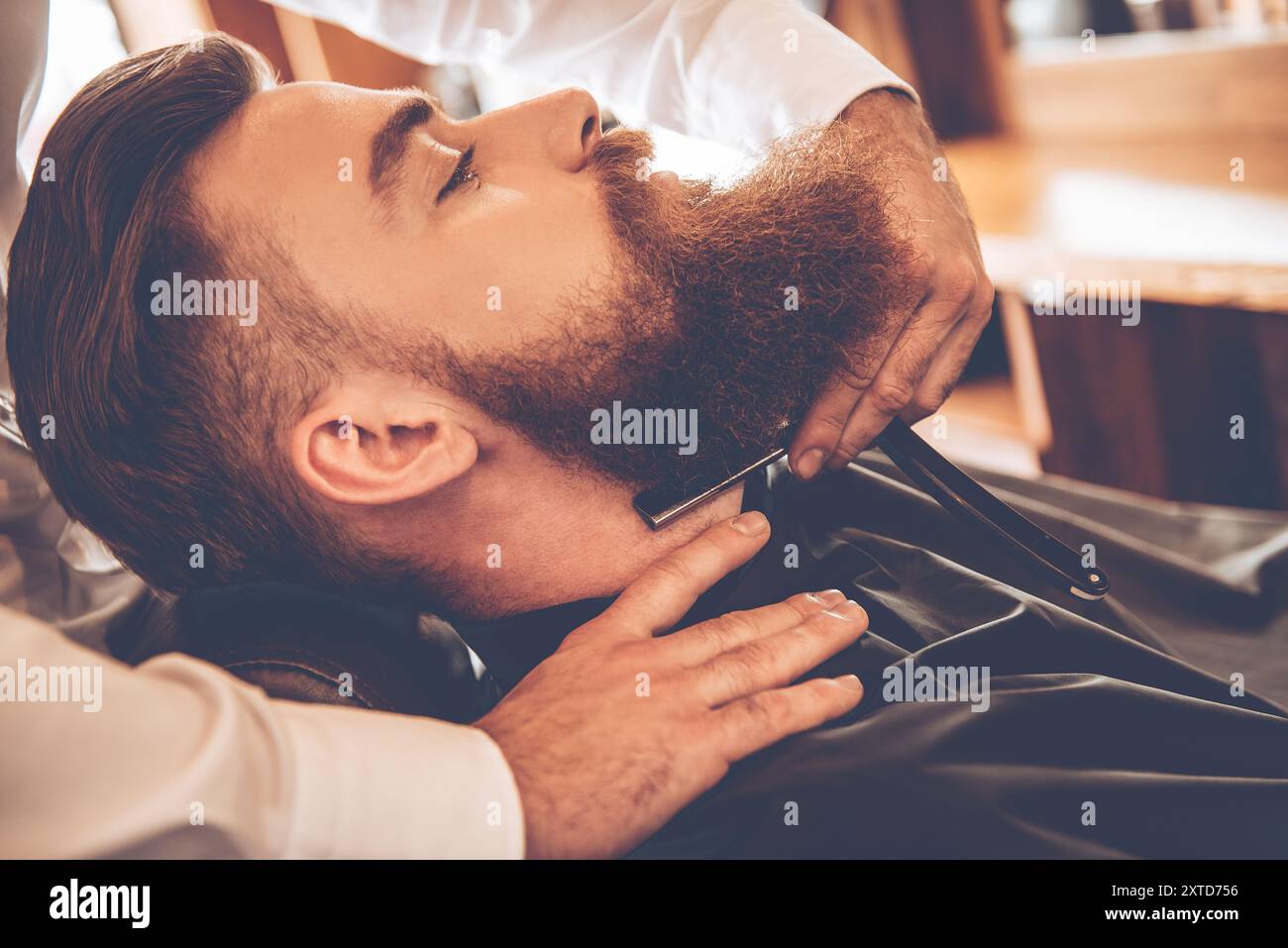 Sharp and dangerous. Close-up side view of young bearded man getting ...