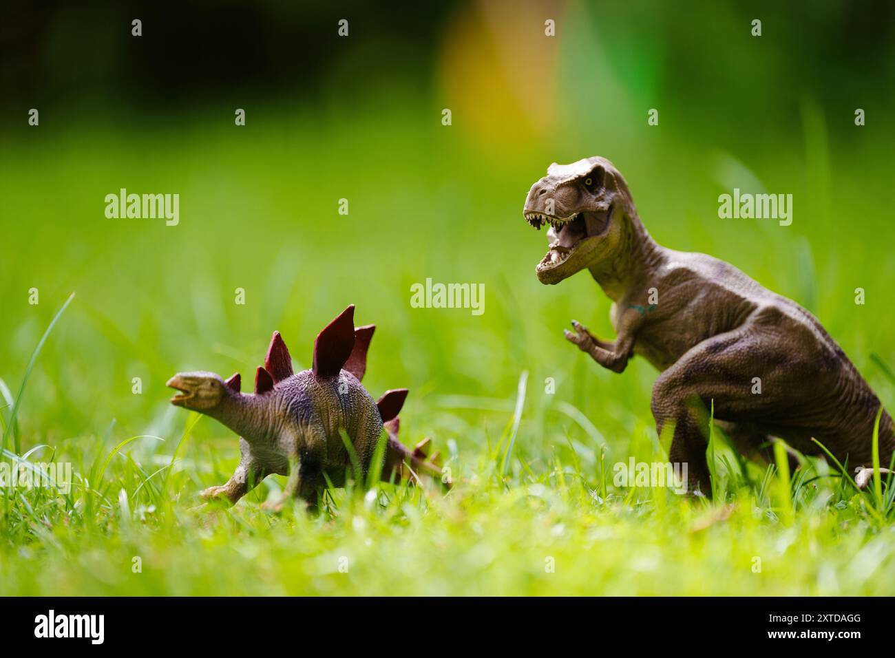 Child playing with dinosaur toy in sunny garden. Young paleontologist ...
