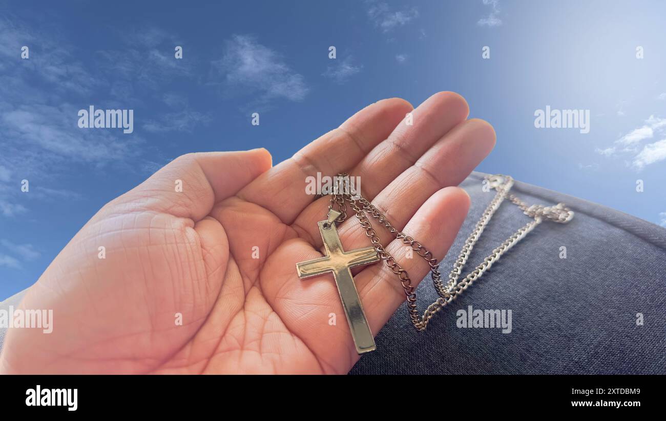 A brown wooden cross resting in an open palm, symbolizing the spreading ...