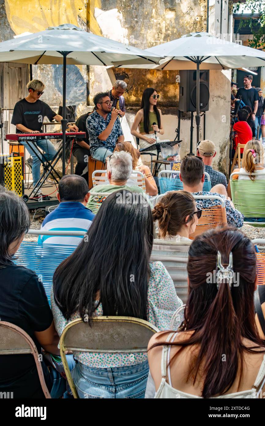 A busy audience watches a singing group performing in the Hin Bus Depot in George Town, Penang ...