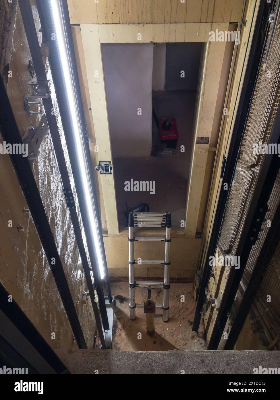 Deep shaft with ladder and open door, reconstruction of old elevator ...