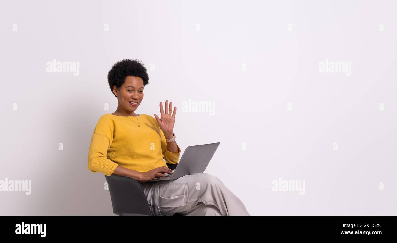 Smiling manager waving hand and talking over video call while sitting ...