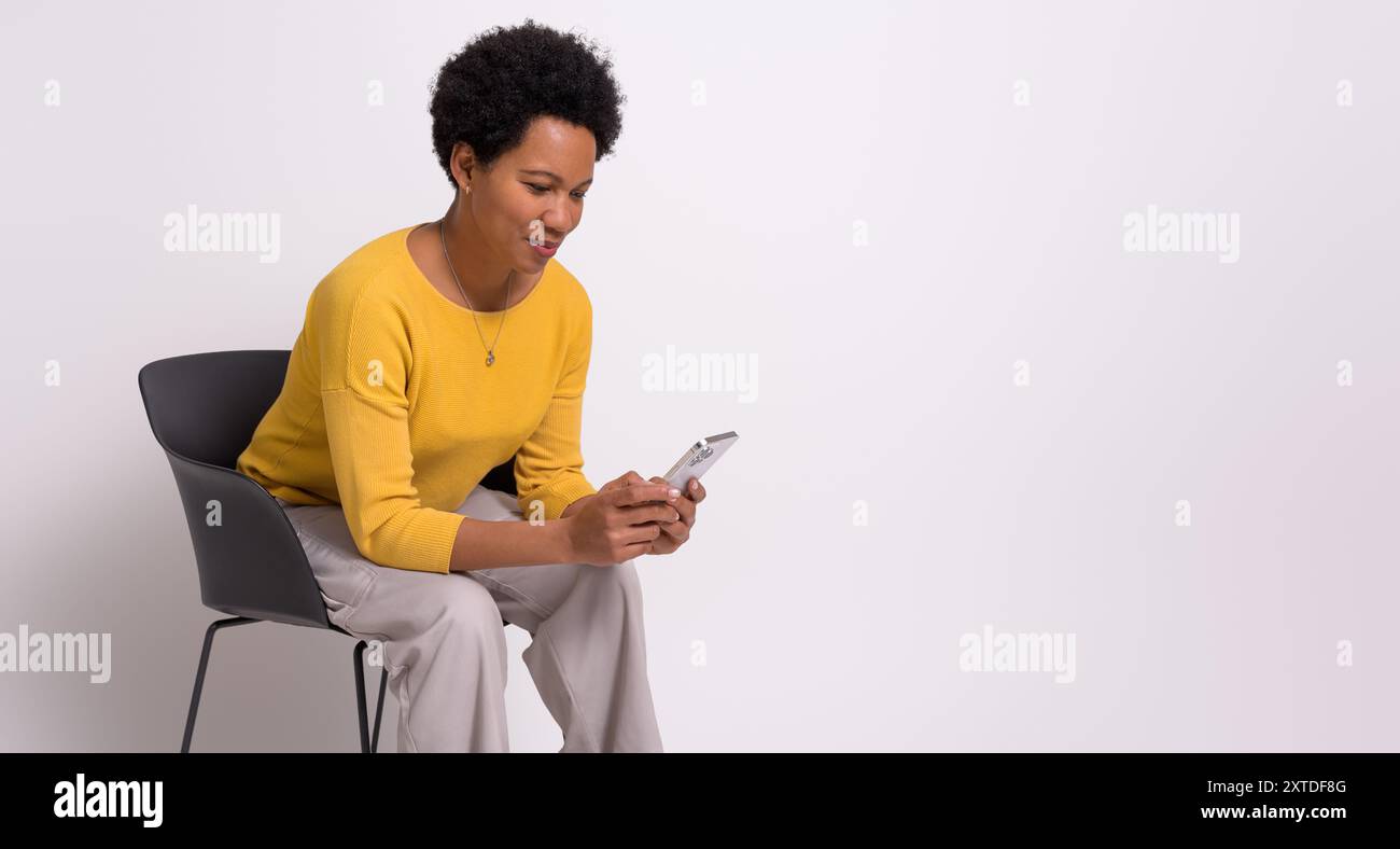 Confident female entrepreneur texting over smart phone while sitting on ...