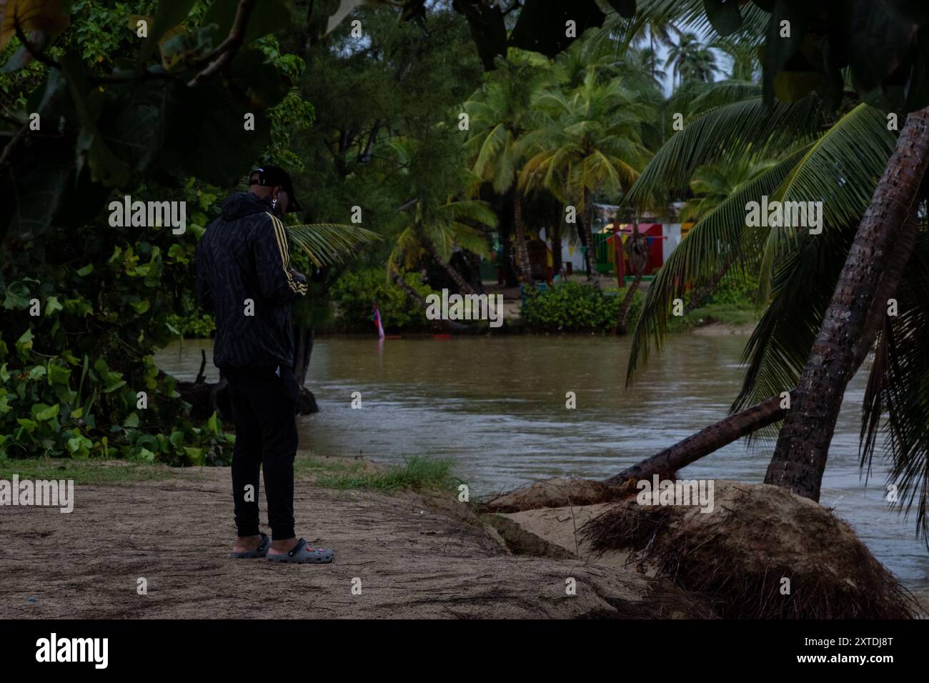 A man looks at the flooding caused by Tropical Storm Ernesto at Río ...
