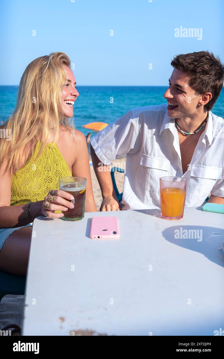 Happy young couple on vacation,drinking in restaurant.Vertical Stock ...