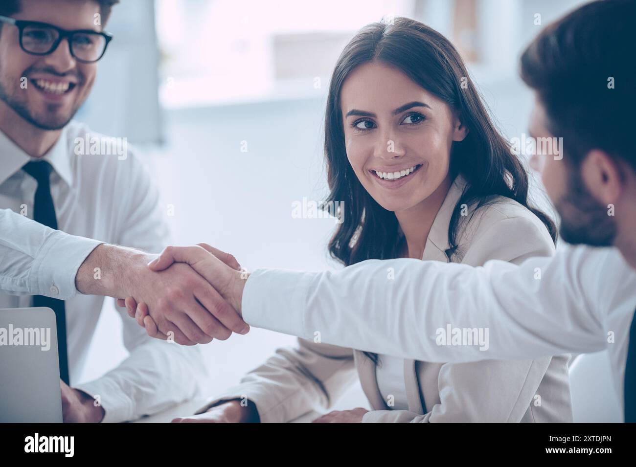 Business handshake. Close-up of two young man shaking hands with smile ...