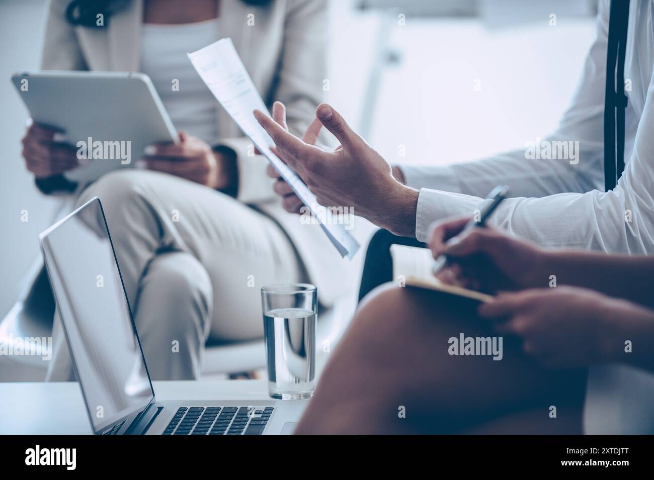 Paperwork. Close-up part of group of people brainstorming and holding documents and digital ...