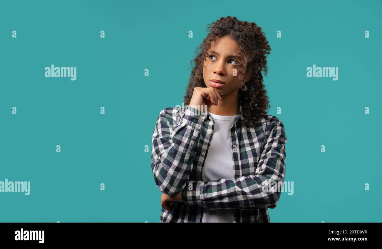 Thinking around african woman, blue background. Puzzled teenager ...