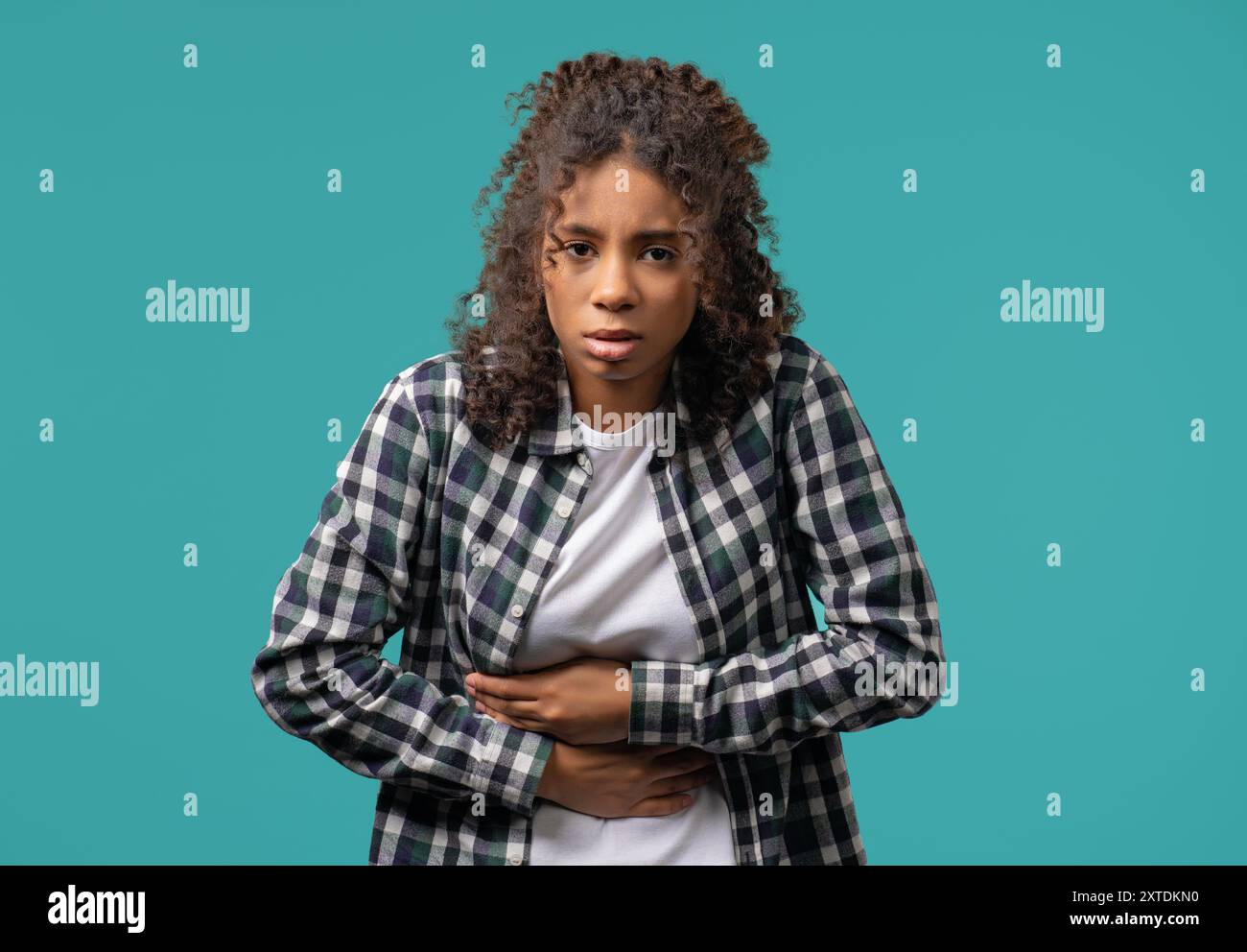 Teenager girl squeezing belly with hands. abdominal pain, suffering ...