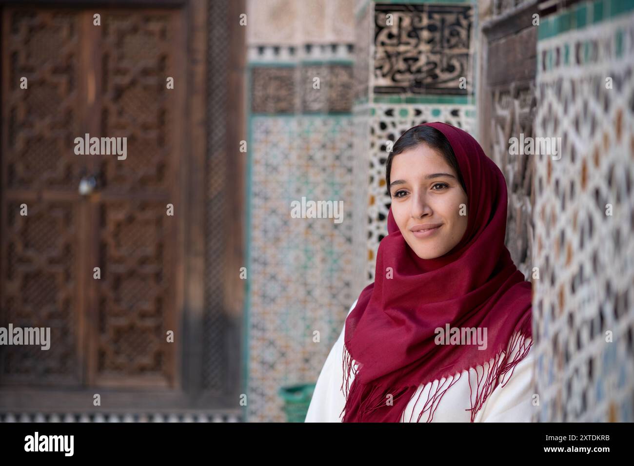 Portrait of muslim woman posing in traditional clothing with red hijab ...
