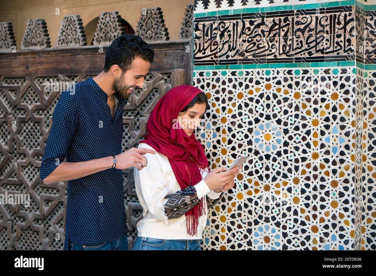 Smiling muslim couple looking at cellphone Stock Photo - Alamy