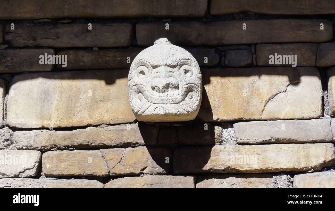 Ancient stone face carving representing inca god, embedded in a wall ...