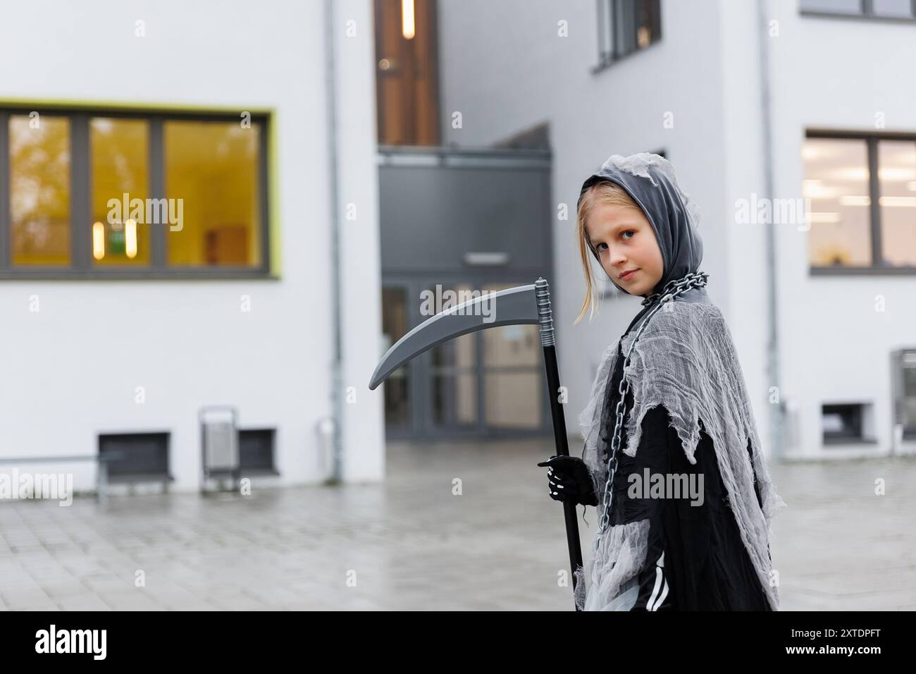 Portrait of kid in grim reaper Halloween costume with scythe and bag ...