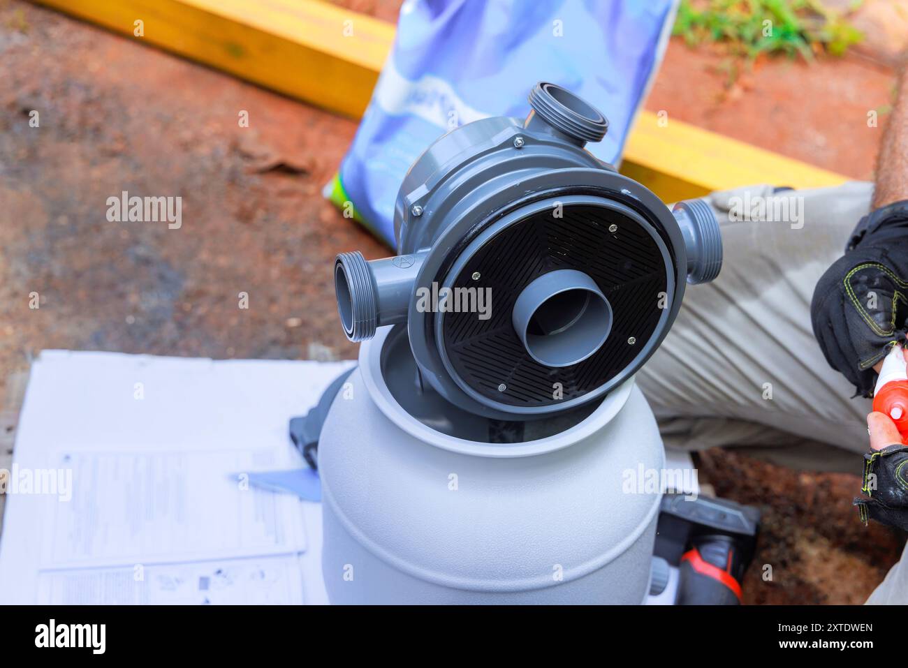 Worker installing sand filter system tank equipment for cleaning ...