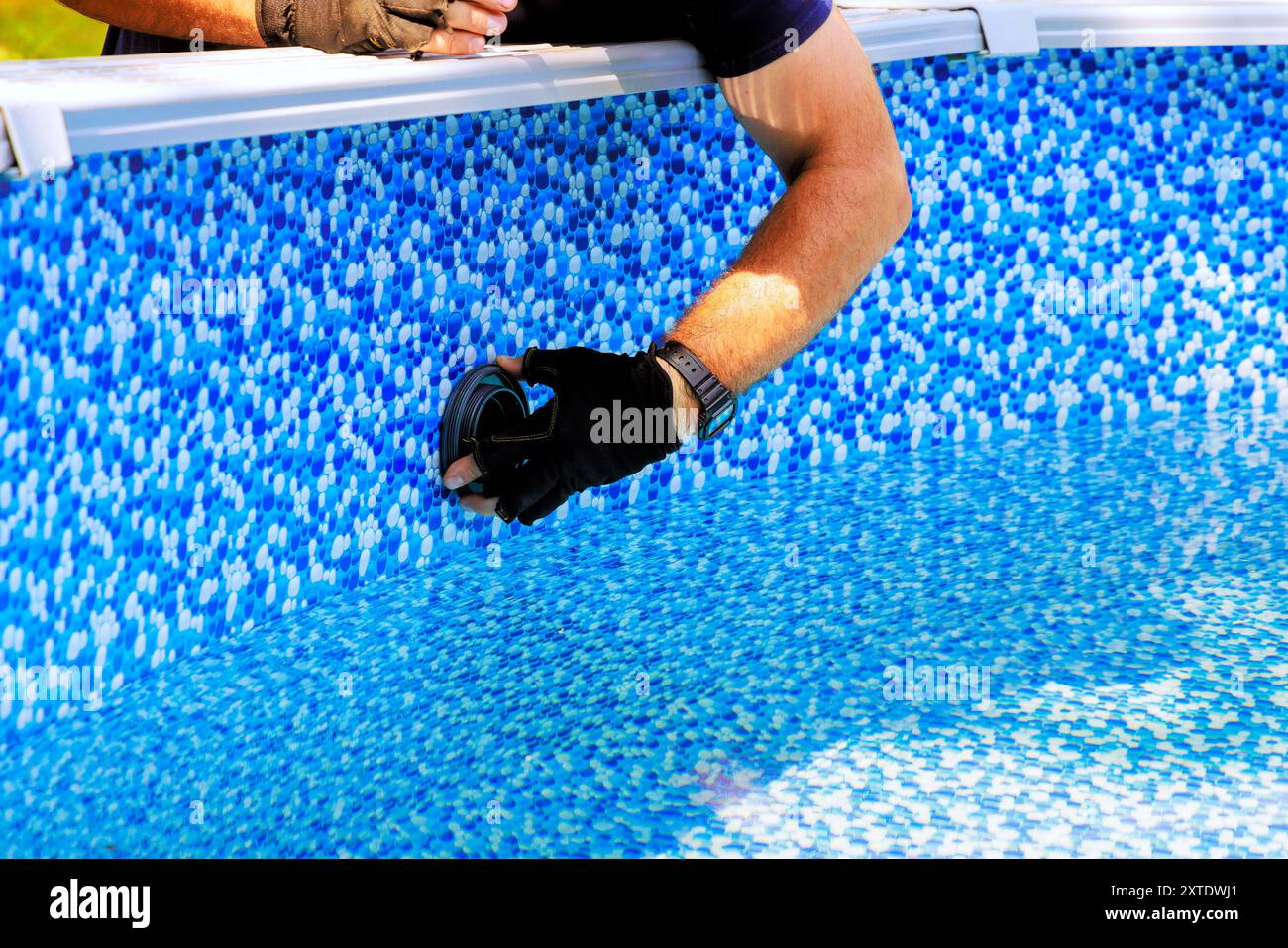 Worker installing water filtration system chlorination in swimming pool ...