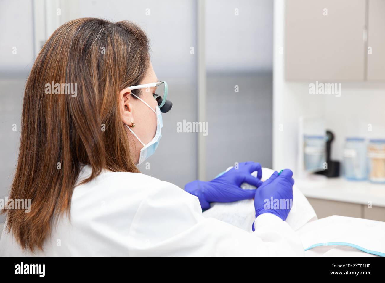 Dermatologist carrying out a skin biopsy on the face of a senior adult ...