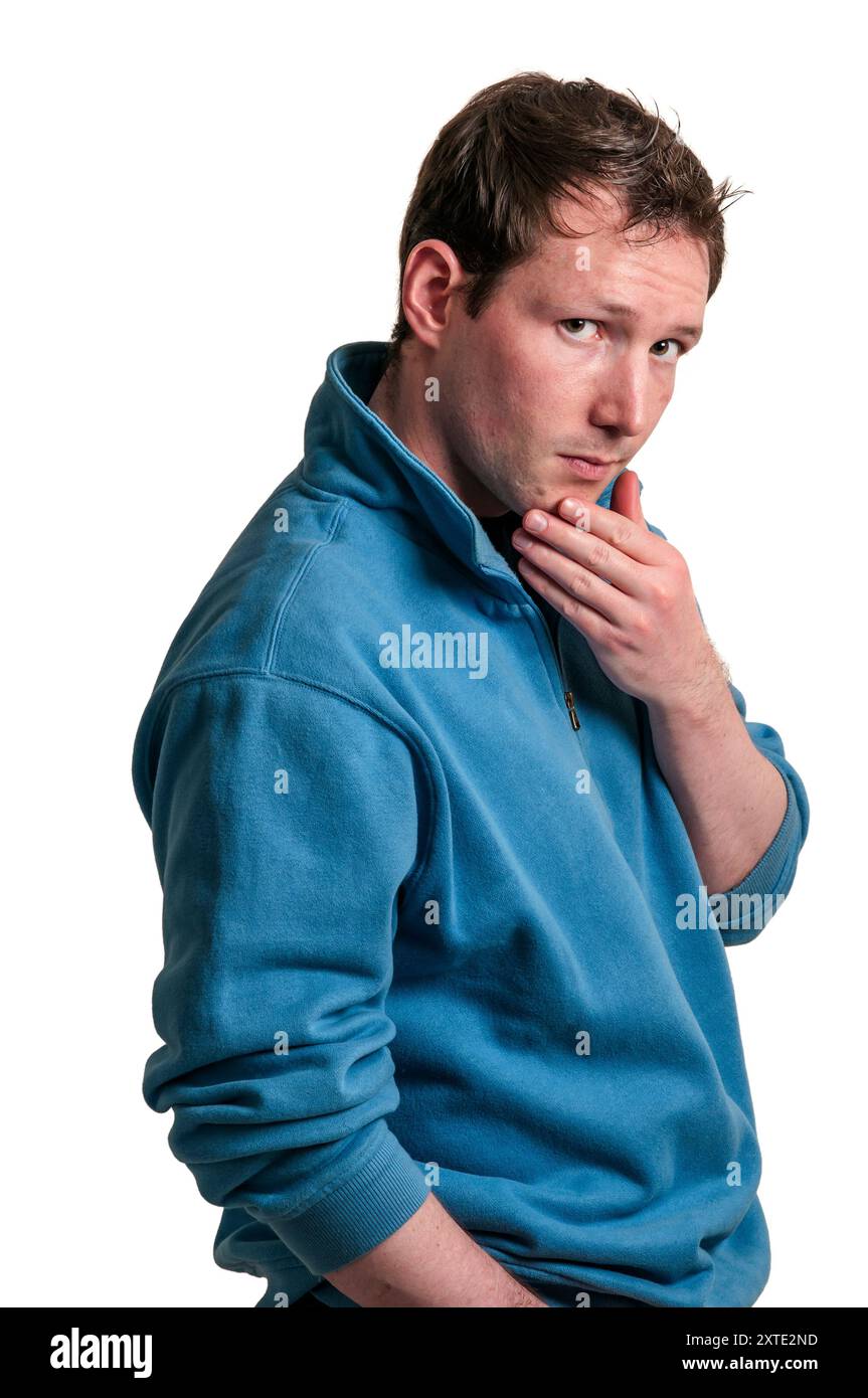 Wide upper body view of a young man with a bold look into the camera ...