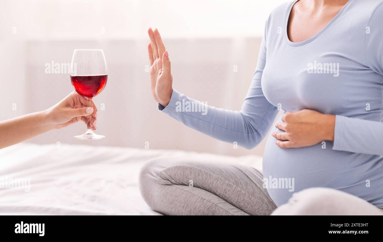 Unrecognizable Pregnant Girl Refusing To Take Wine Sitting On Bed Stock ...