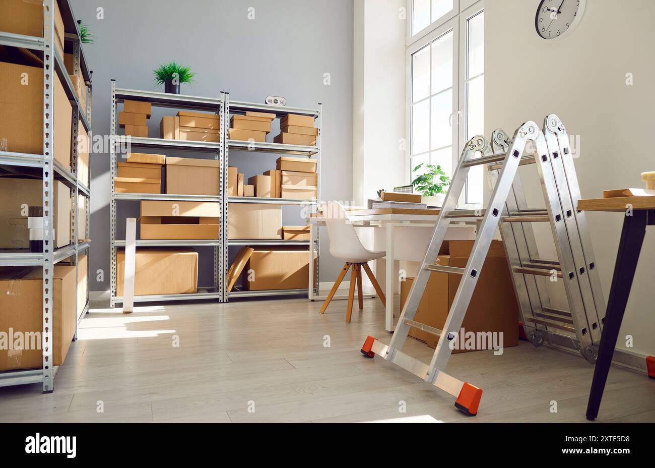 Empty space with office desk in warehouse with shelves filled cardboard ...