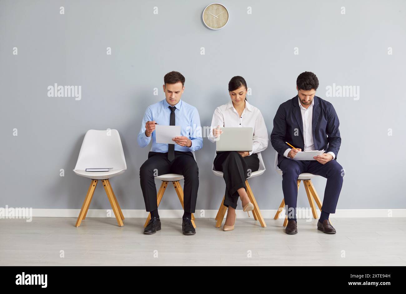 Diverse job candidates sitting on office chairs in row, business people ...