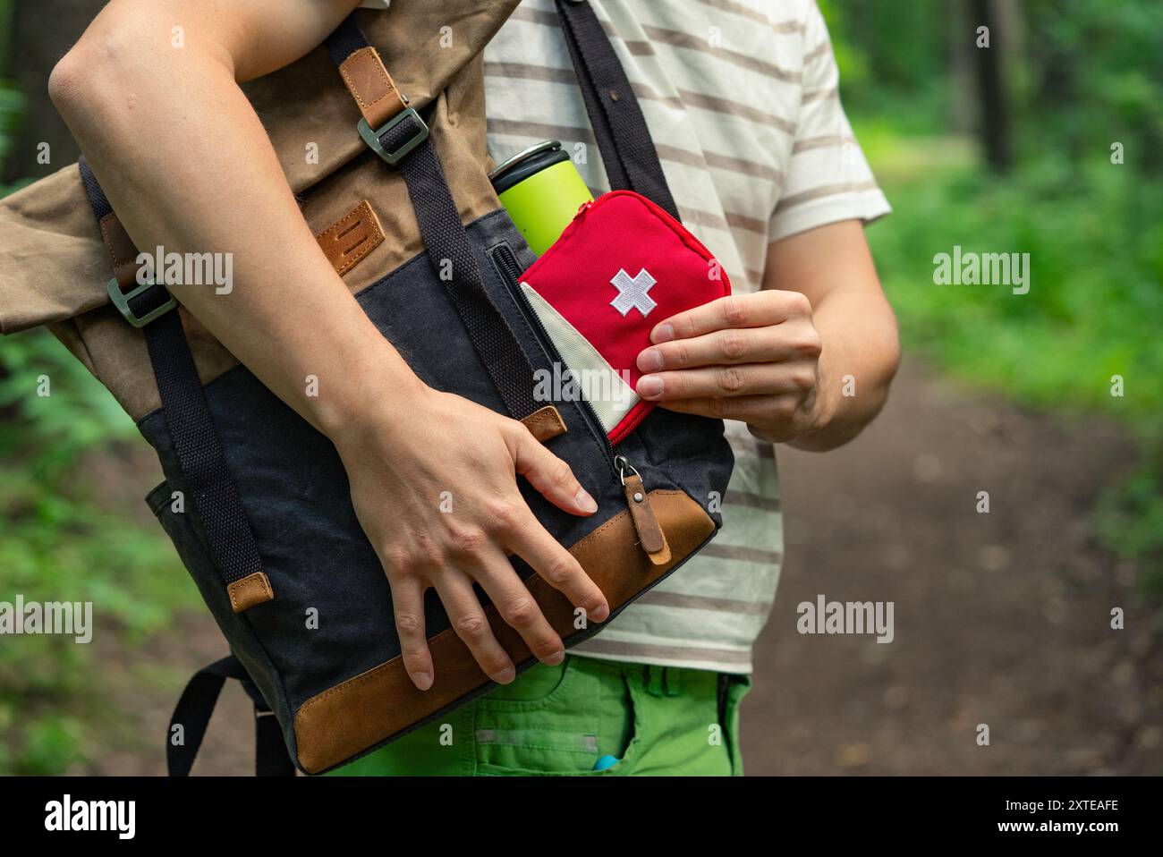 Close-up of a person taking a first aid kit out of a backpack while on ...