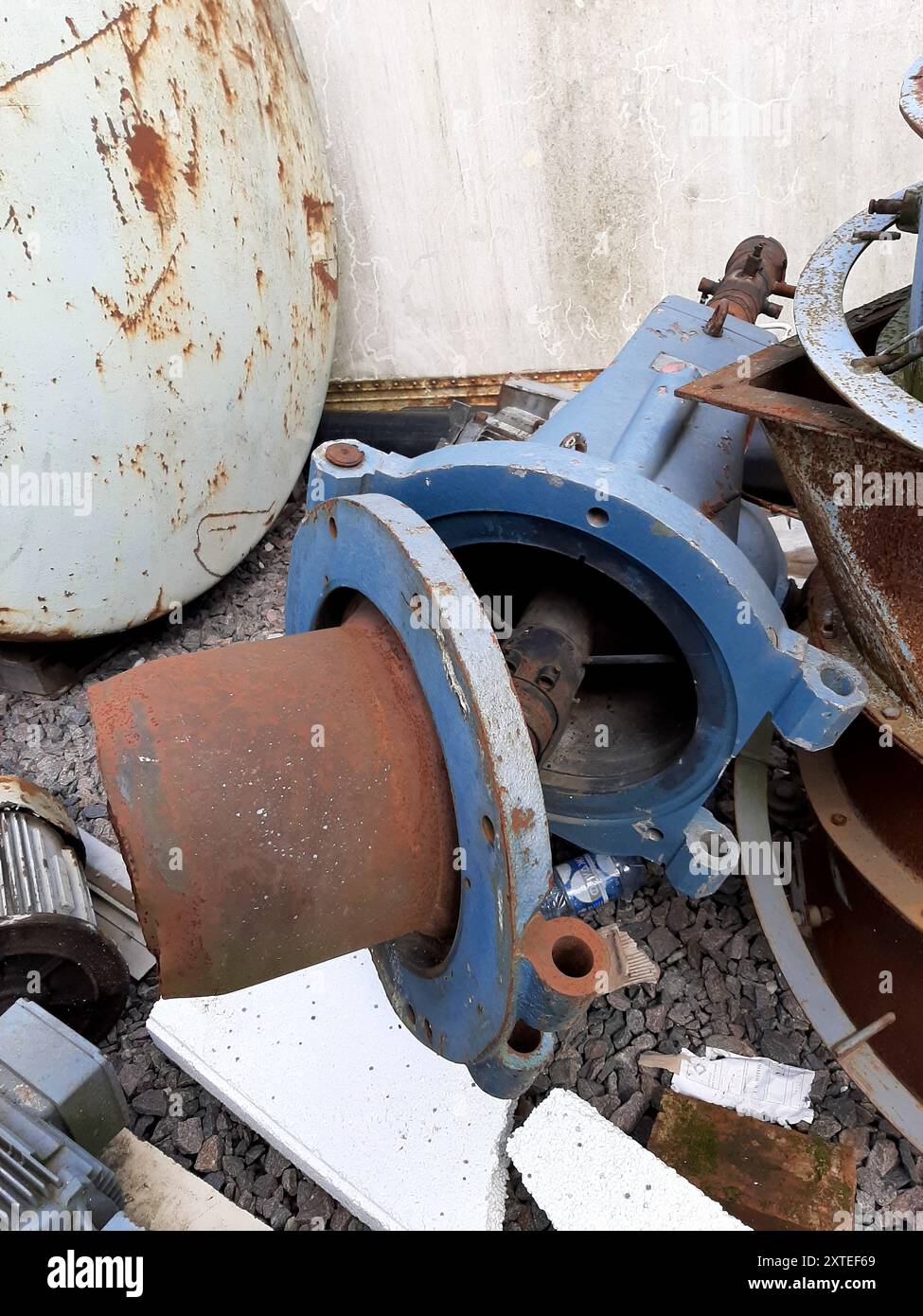 An old diesel boiler burner lies abandoned among scrap metal at a ...