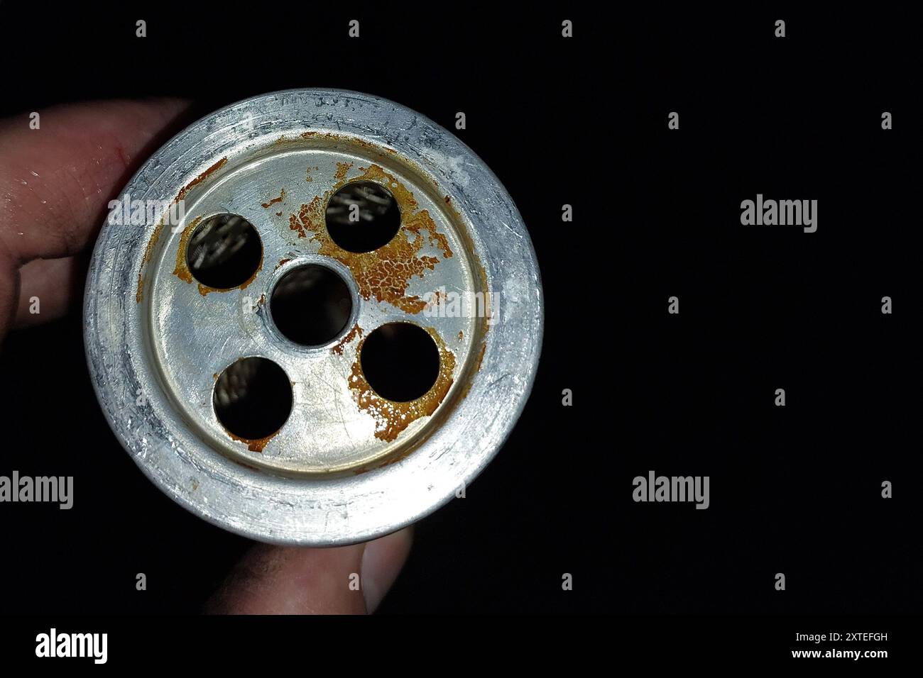 A close-up of a fuel filter mesh highlights visible impurities and rust ...