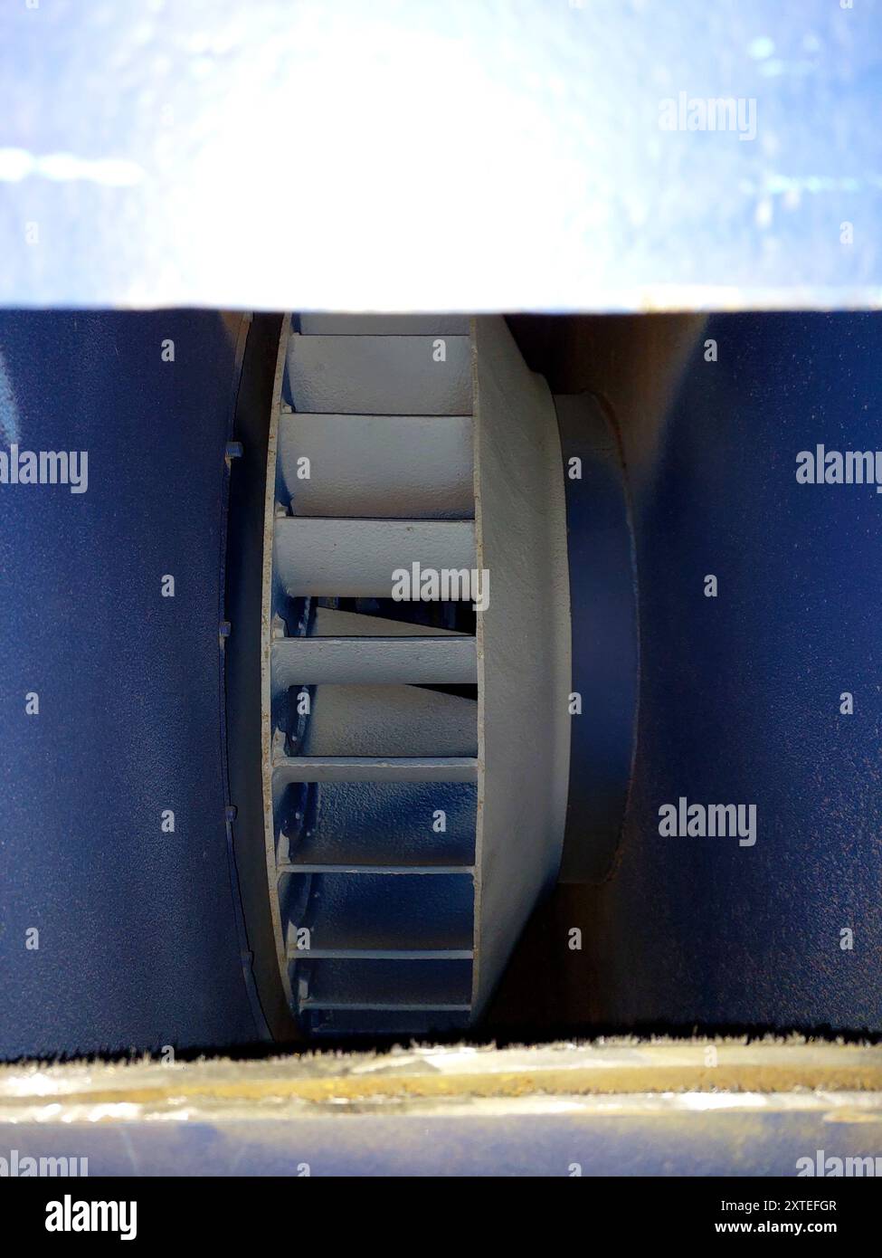 A close-up view of a large industrial exhaust fan impeller inside its ...