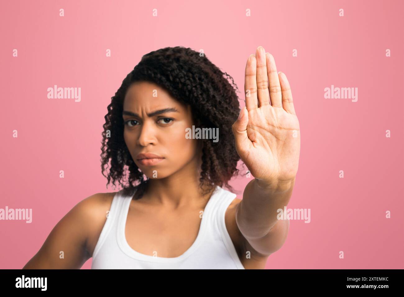 Afro girl showing stop sign on white background Stock Photo - Alamy