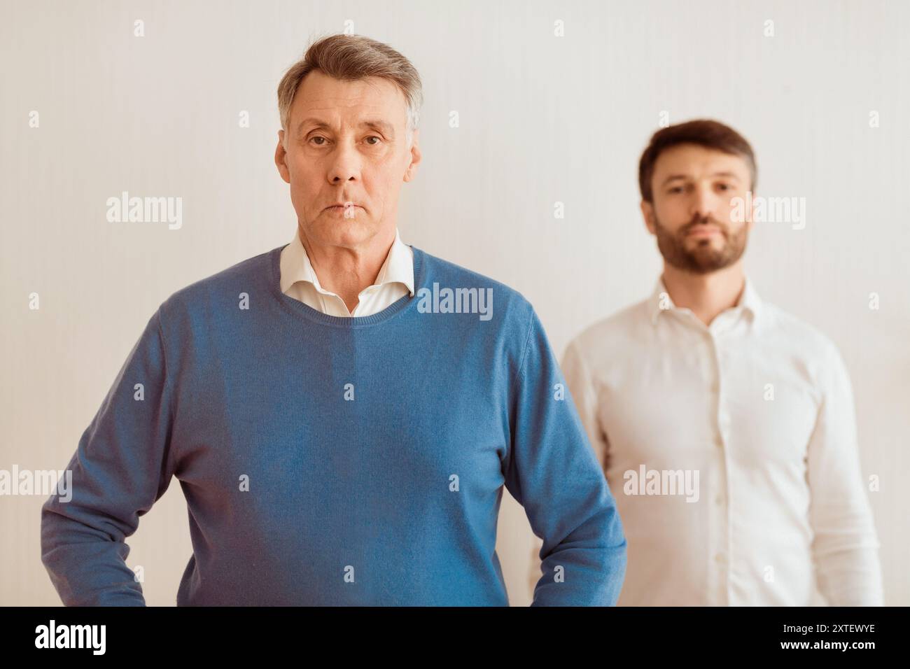 Mature Son Standing Overshadowed By His Elderly Father, White ...