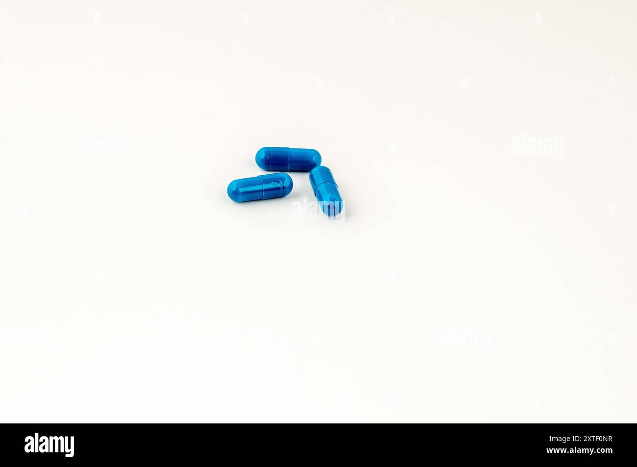 Concept grouping of three blue colored capsules on white background ...