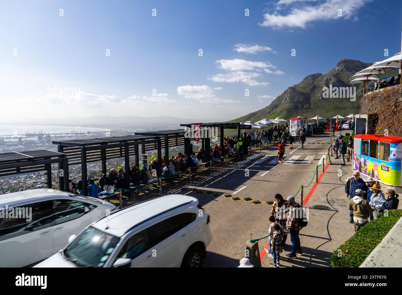 Tourists wait in line for their turn to ride the cable car up Table ...