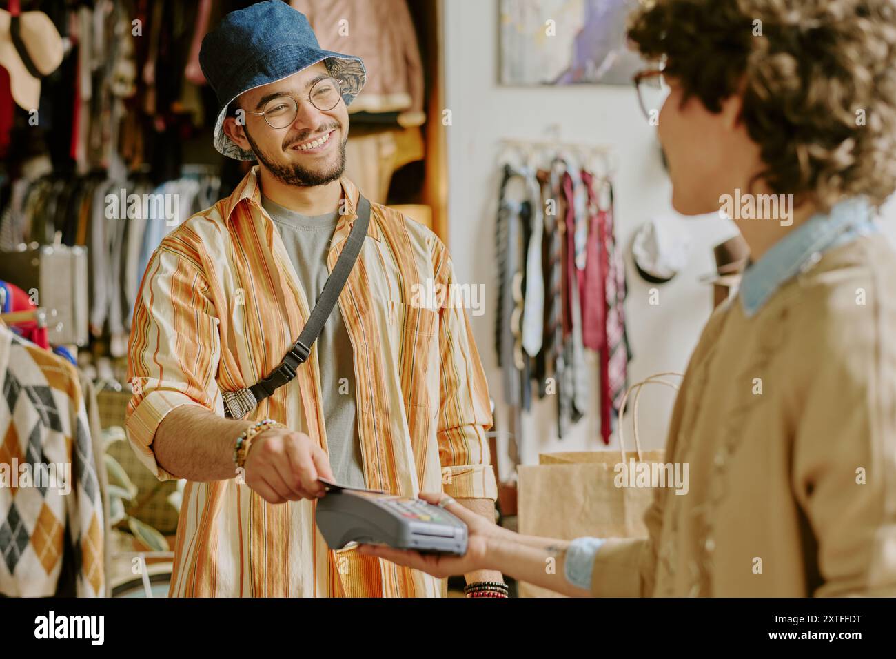 Smiling Man Making Payment in Clothing Store Stock Photo - Alamy
