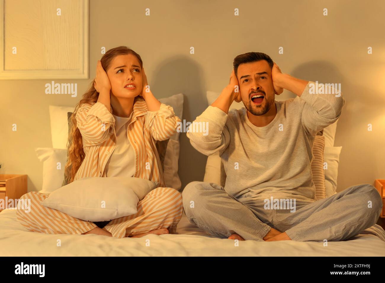 Young couple suffering from loud neighbours in bedroom at night Stock ...