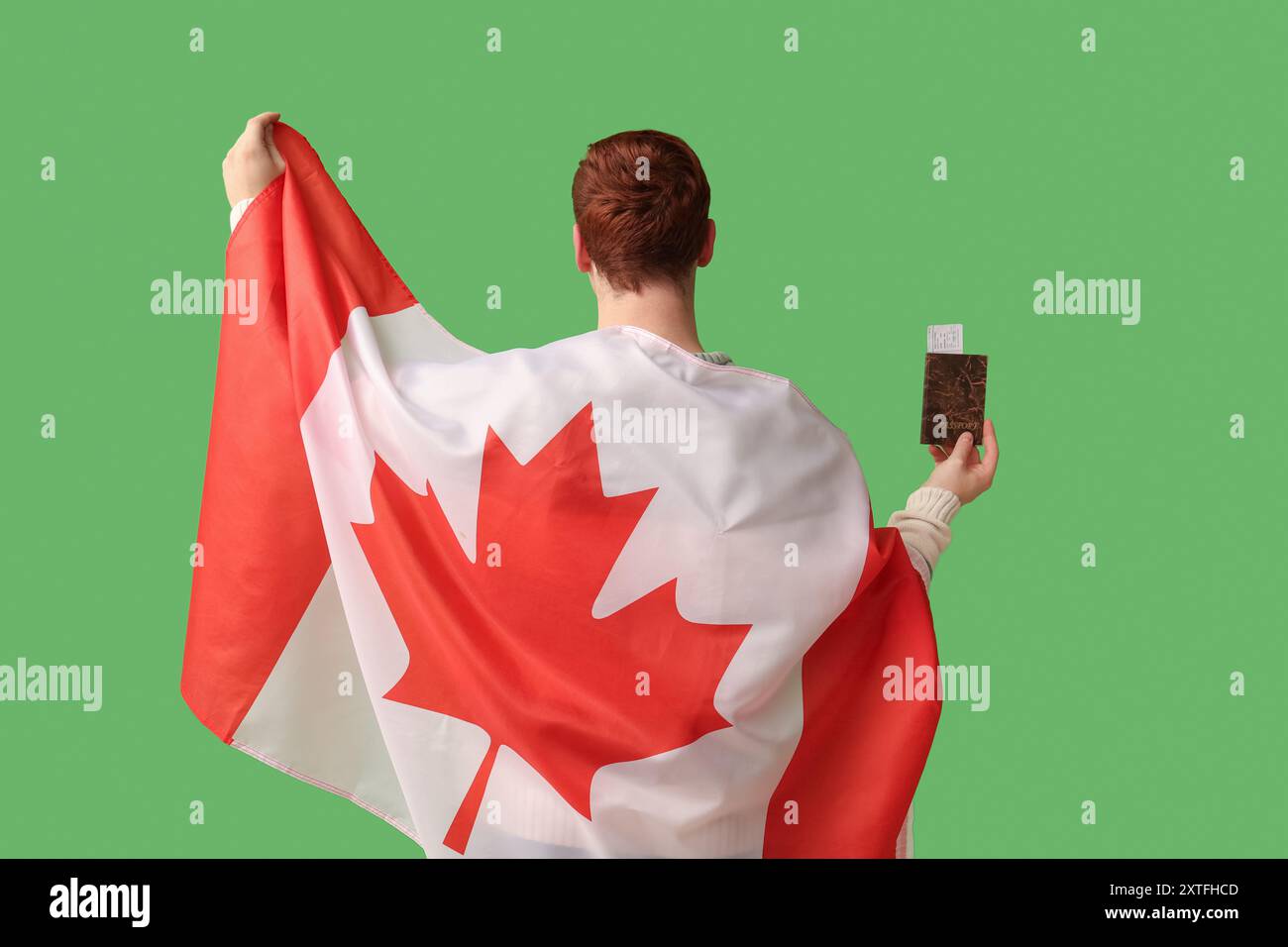Handsome young man with Canadian flag, passport and ticket on green ...