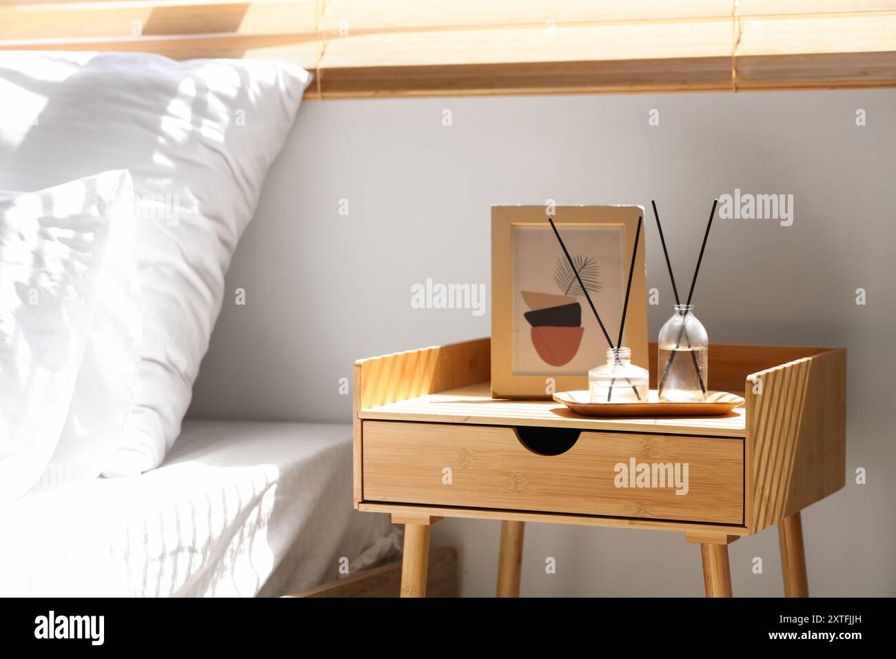 Bedside table with aroma diffuser, tray and photo frame in bedroom ...