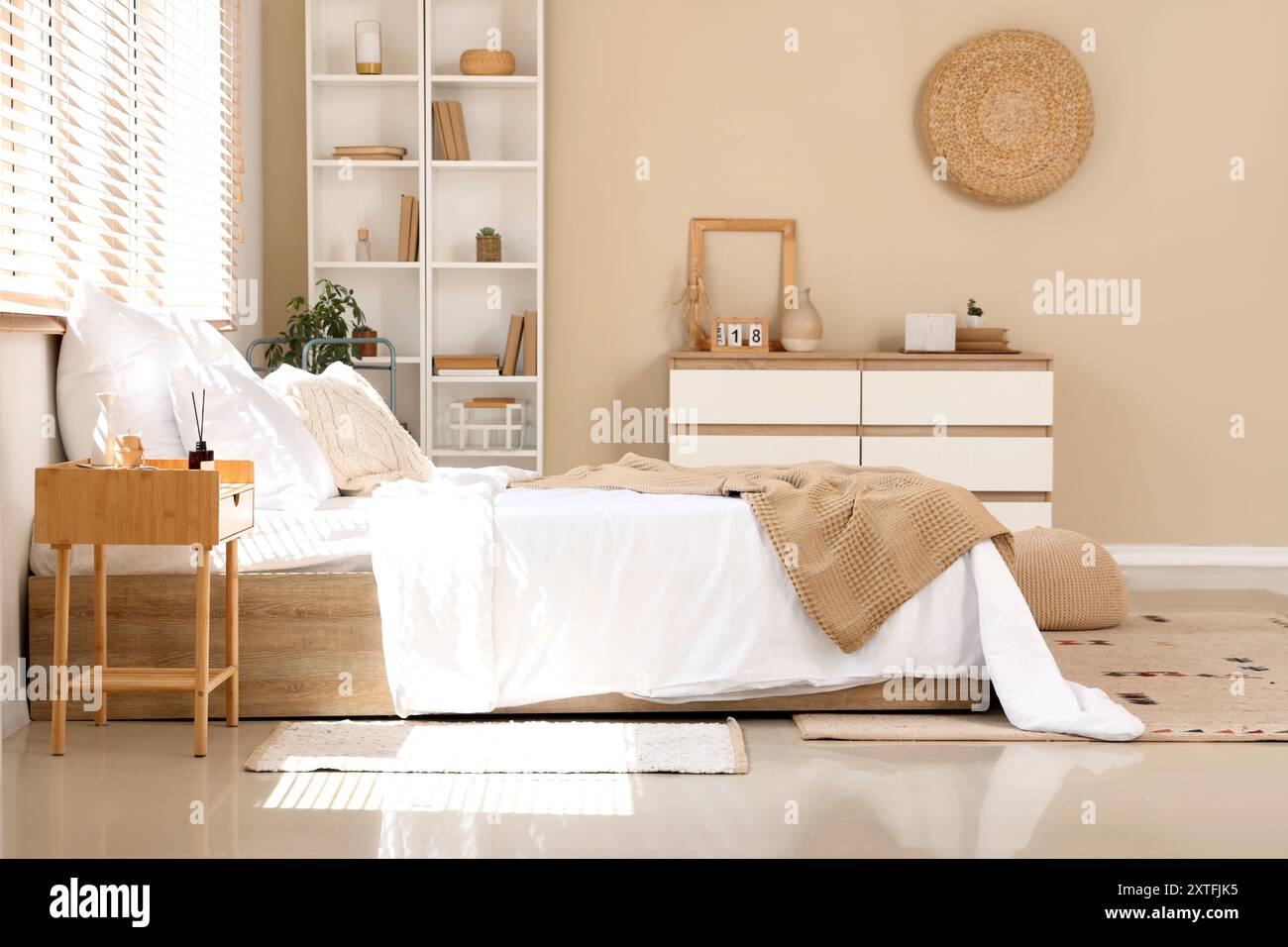 Comfortable bed and table with aroma diffuser near window in bedroom ...