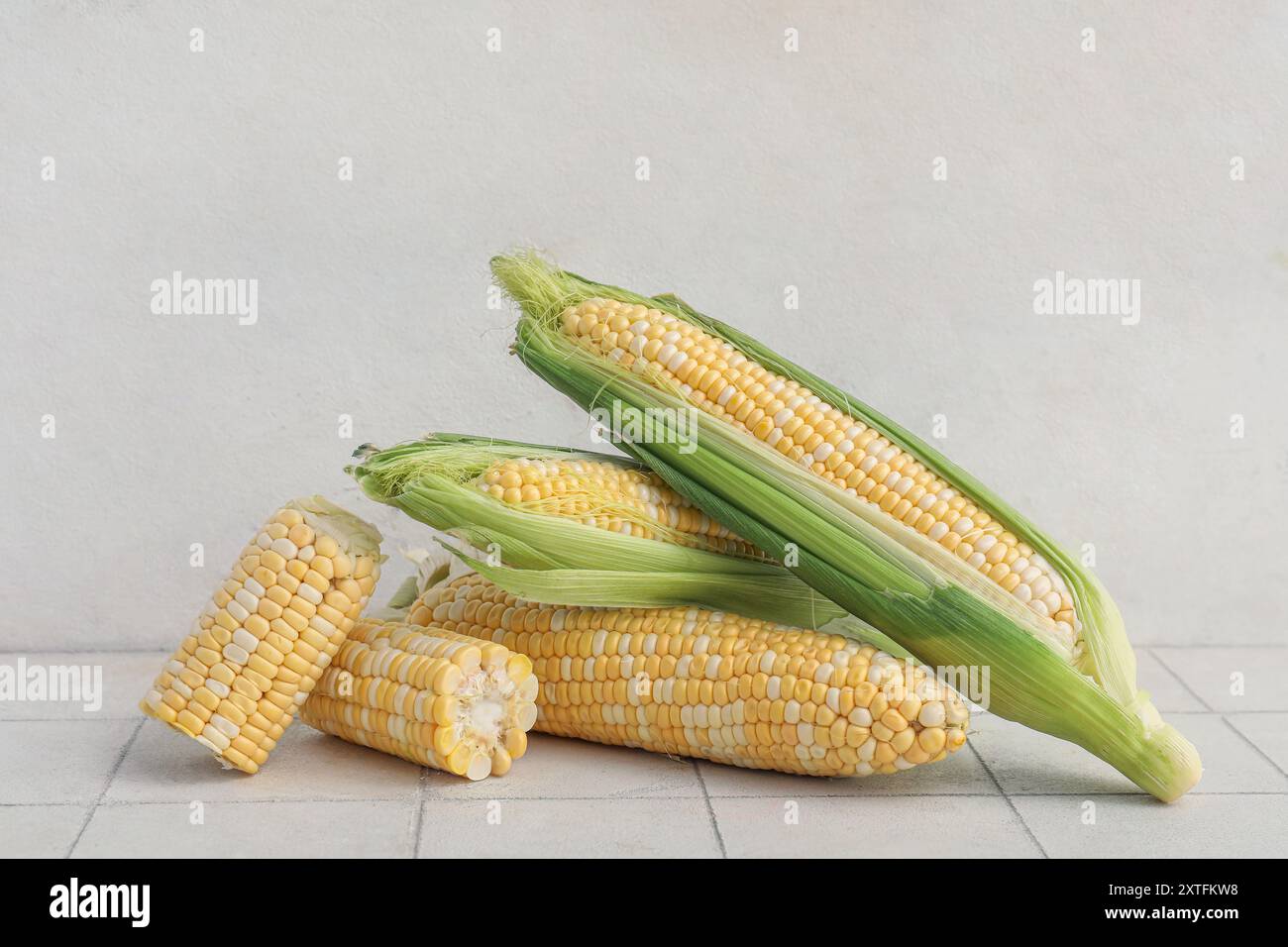 Fresh corn cobs on white tile table Stock Photo - Alamy