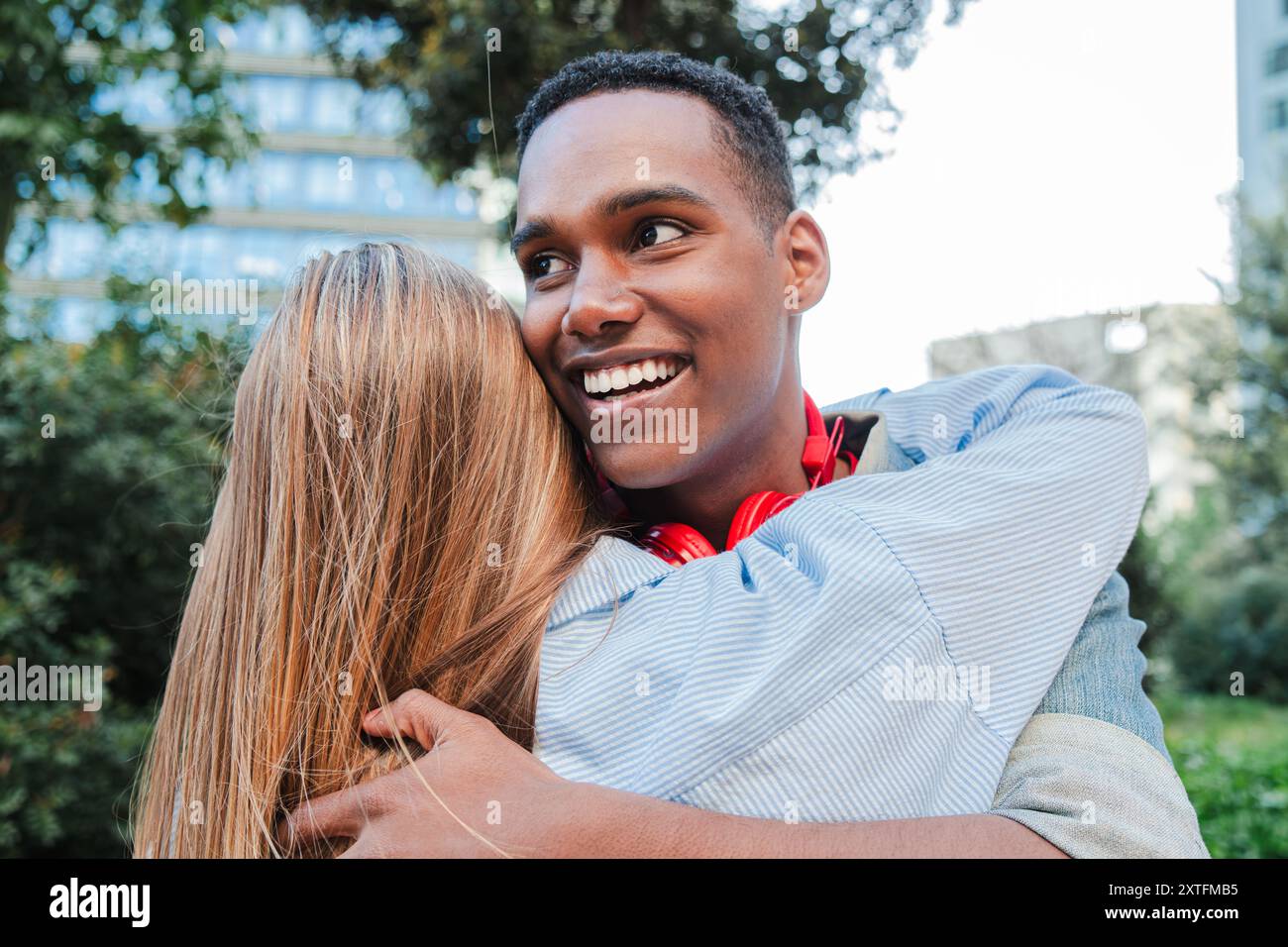 Young African American man giving a tender hug to his girlfriend ...