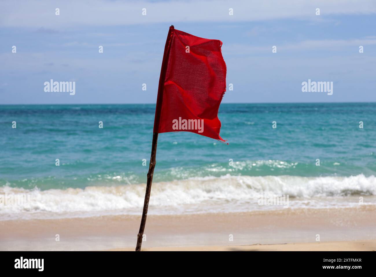 Red warning flag on background of a sea beach. Sign indicating that ...