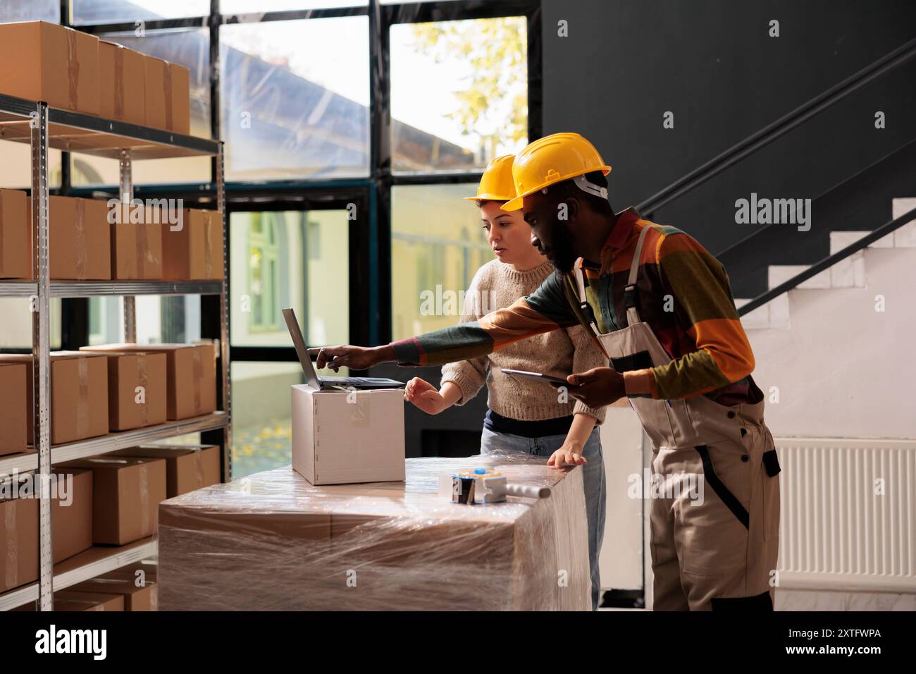 Warehouse employees preparing clients orders using cardboard boxes ...