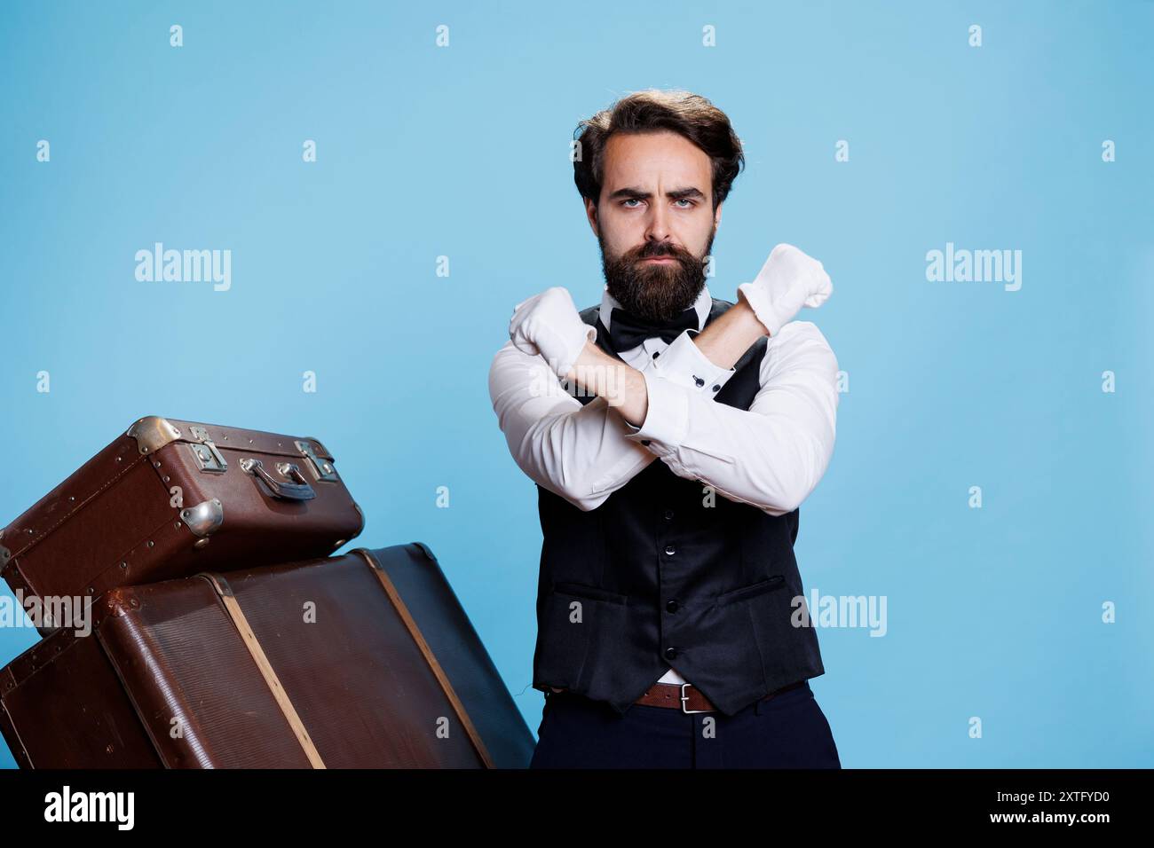 Bellboy presents rejection sign with arms, being displeased and ...