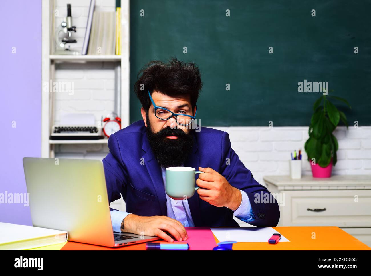 Fatigued school teacher sitting at desk having coffee break. Sleepy ...