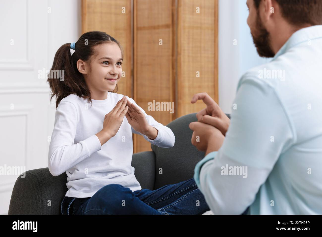 Man and his daughter using sign language for communication at home ...