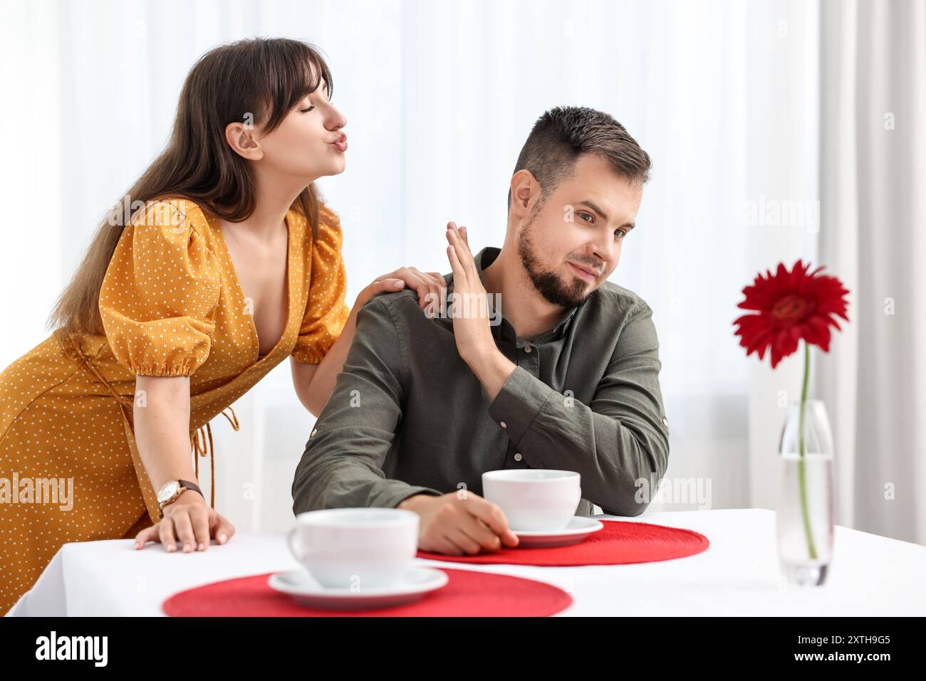 Bad date. Embarrassed man refusing from woman's kiss indoors Stock ...