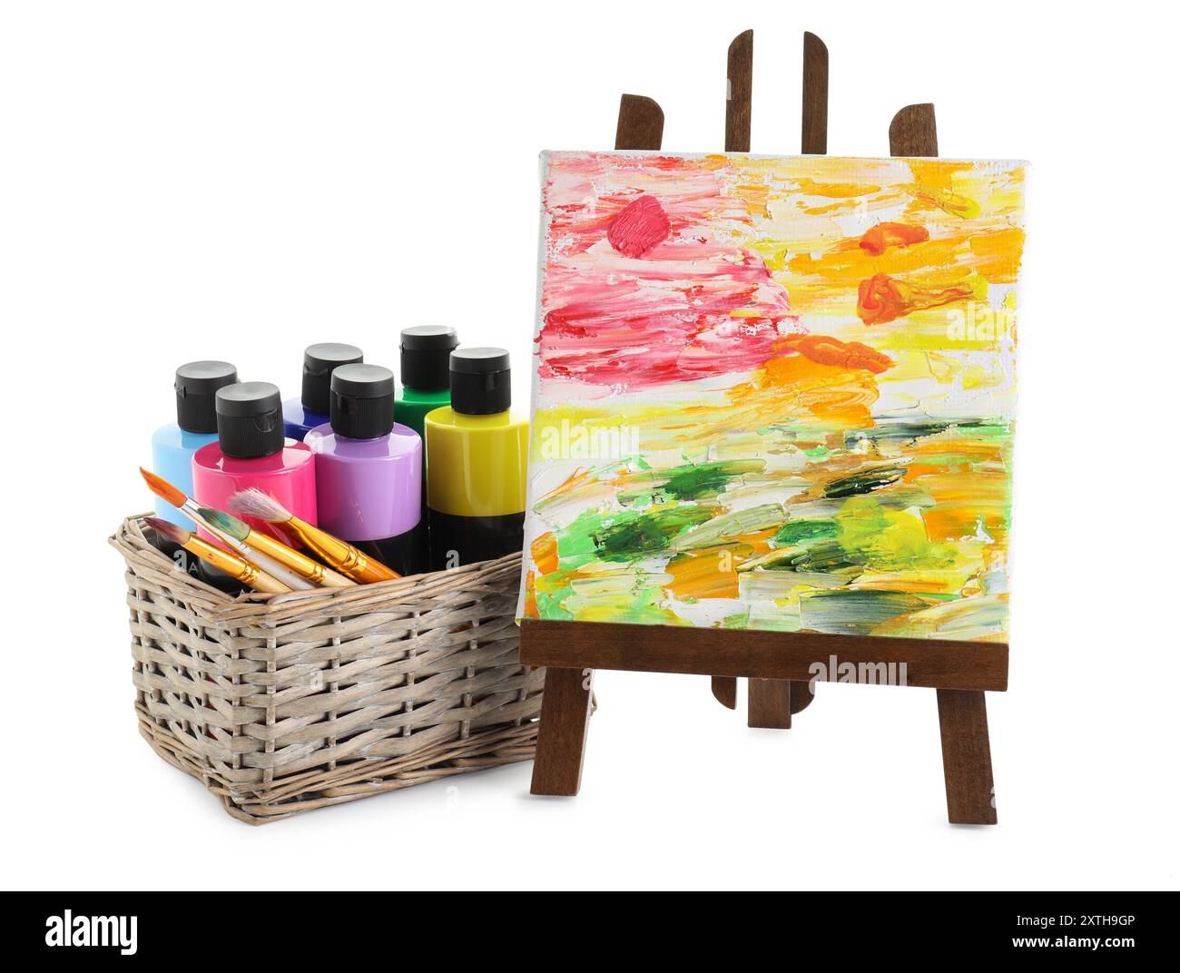 Acrylic paints of different colors with brushes in wicker basket and ...