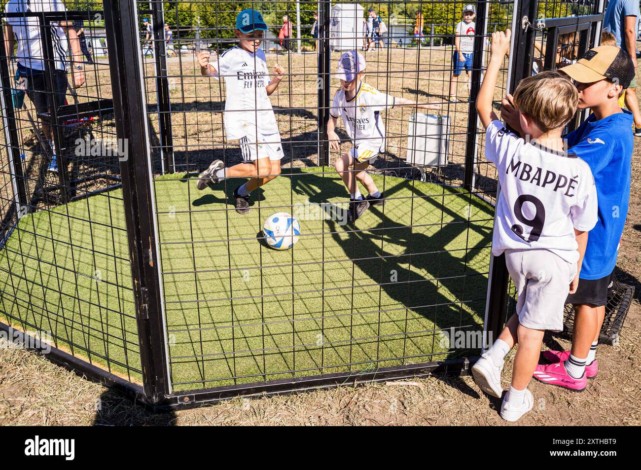 Young fans play 1vs1 football in a cage octagon. Fans of Spanish ...
