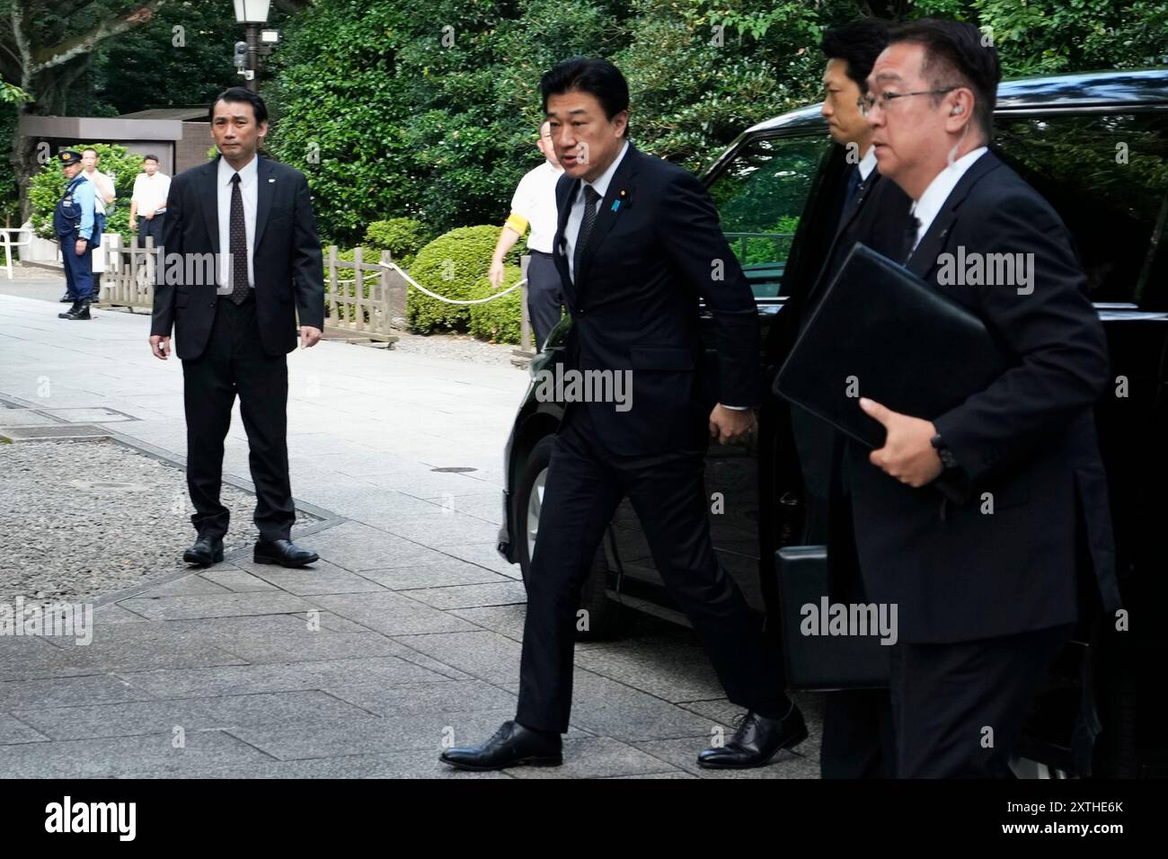 Japanese Defense Minister Minoru Kihara, center, arrives for offering prayer for the war dead at ...