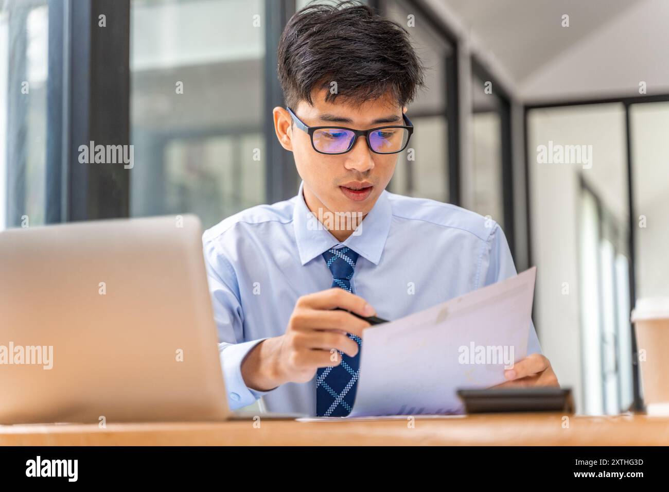 Young businessman working on his project in his office checking ...
